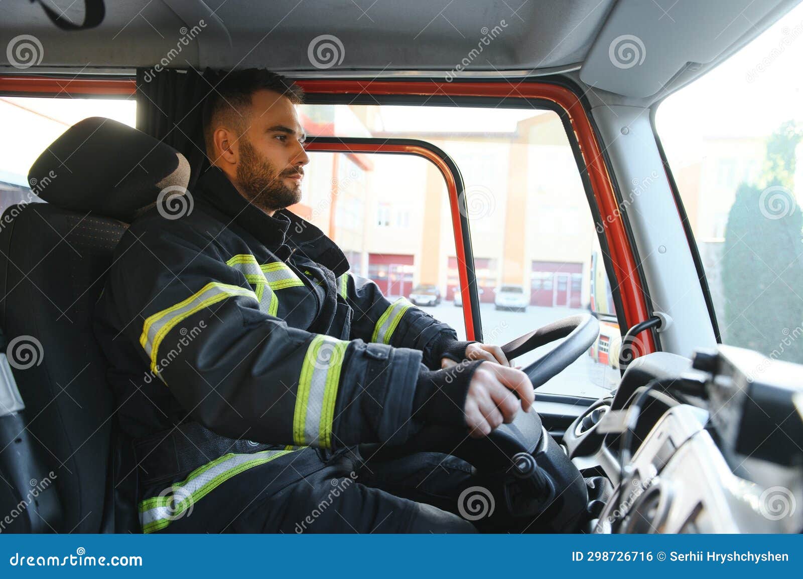 Side View of Firefighter in Protective Uniform Driving Fire Engine ...