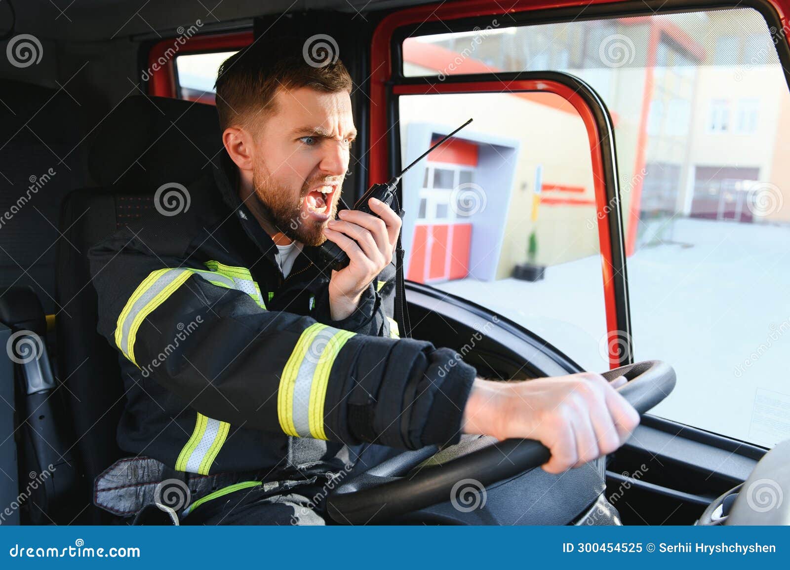 Side View of Firefighter in Protective Uniform Driving Fire Engine ...