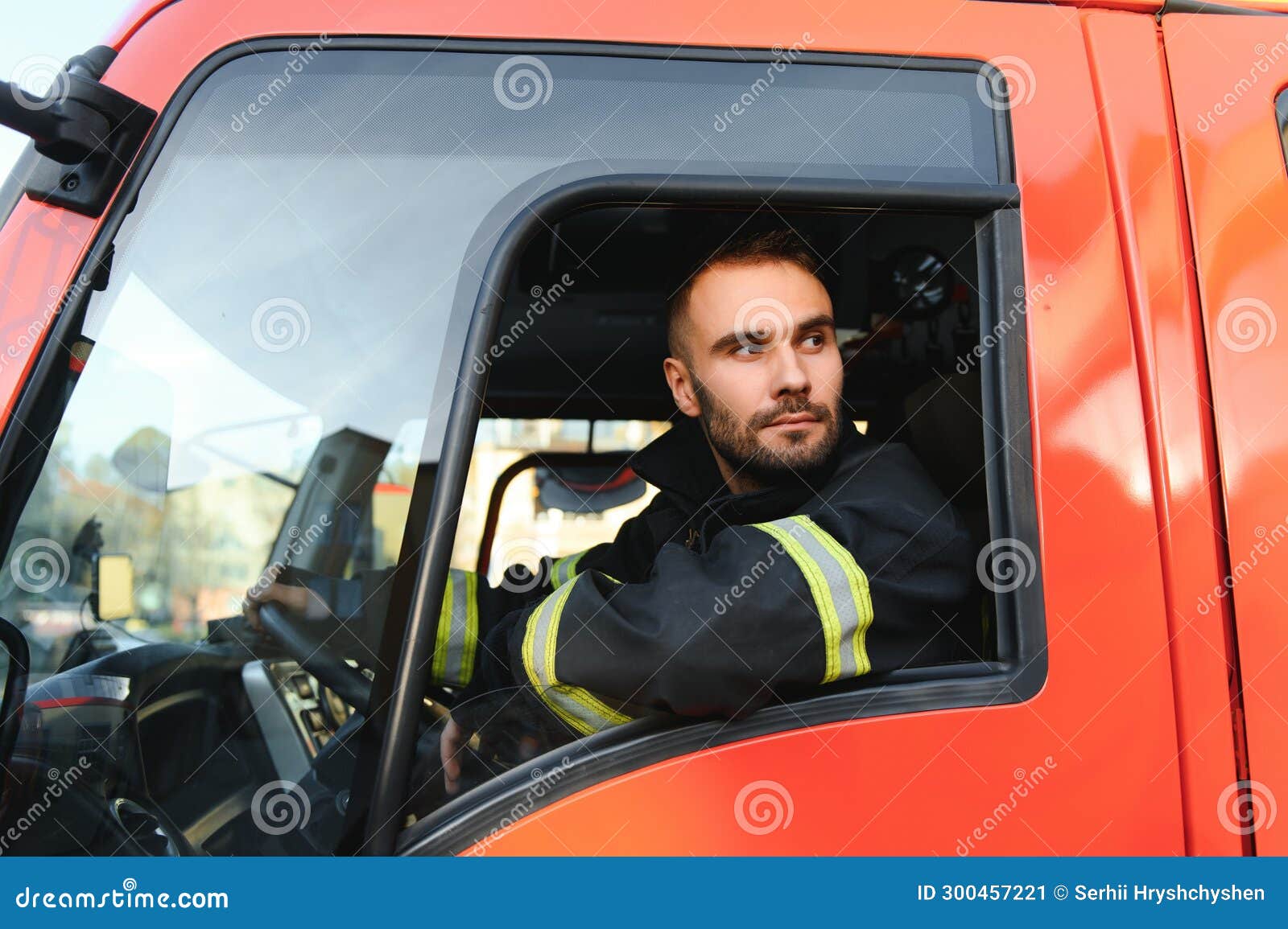 Side View of Firefighter in Protective Uniform Driving Fire Engine ...