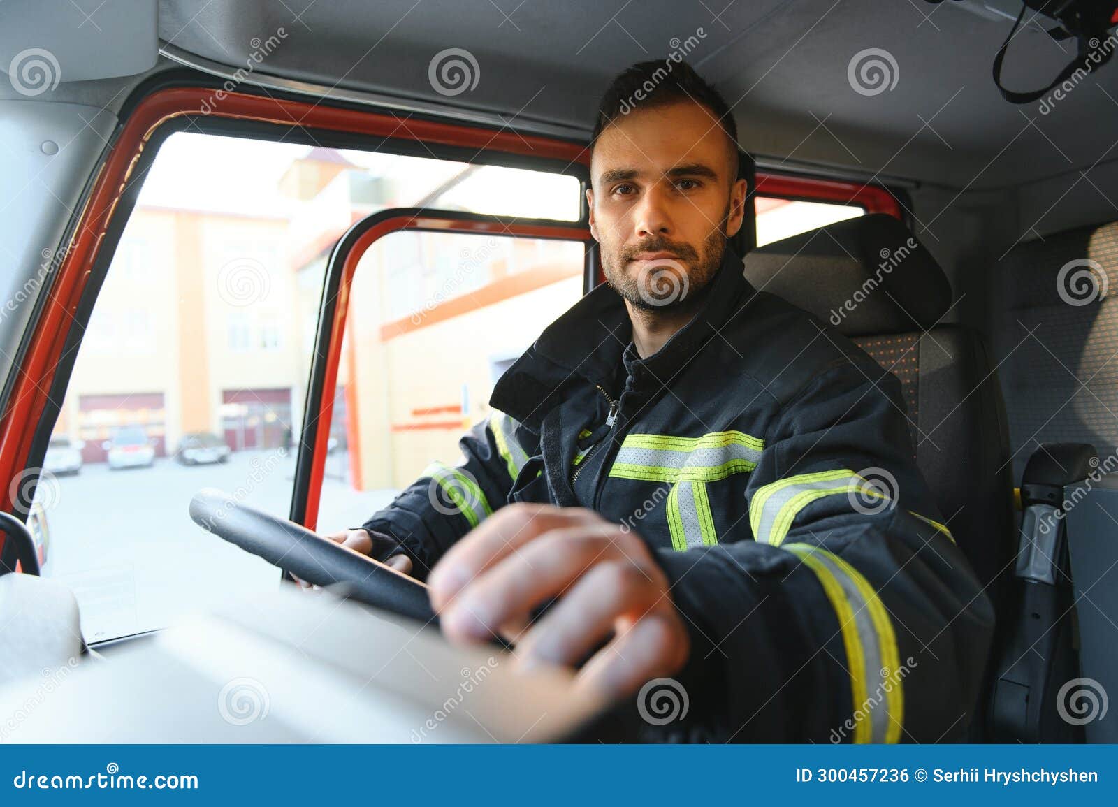 Side View of Firefighter in Protective Uniform Driving Fire Engine ...