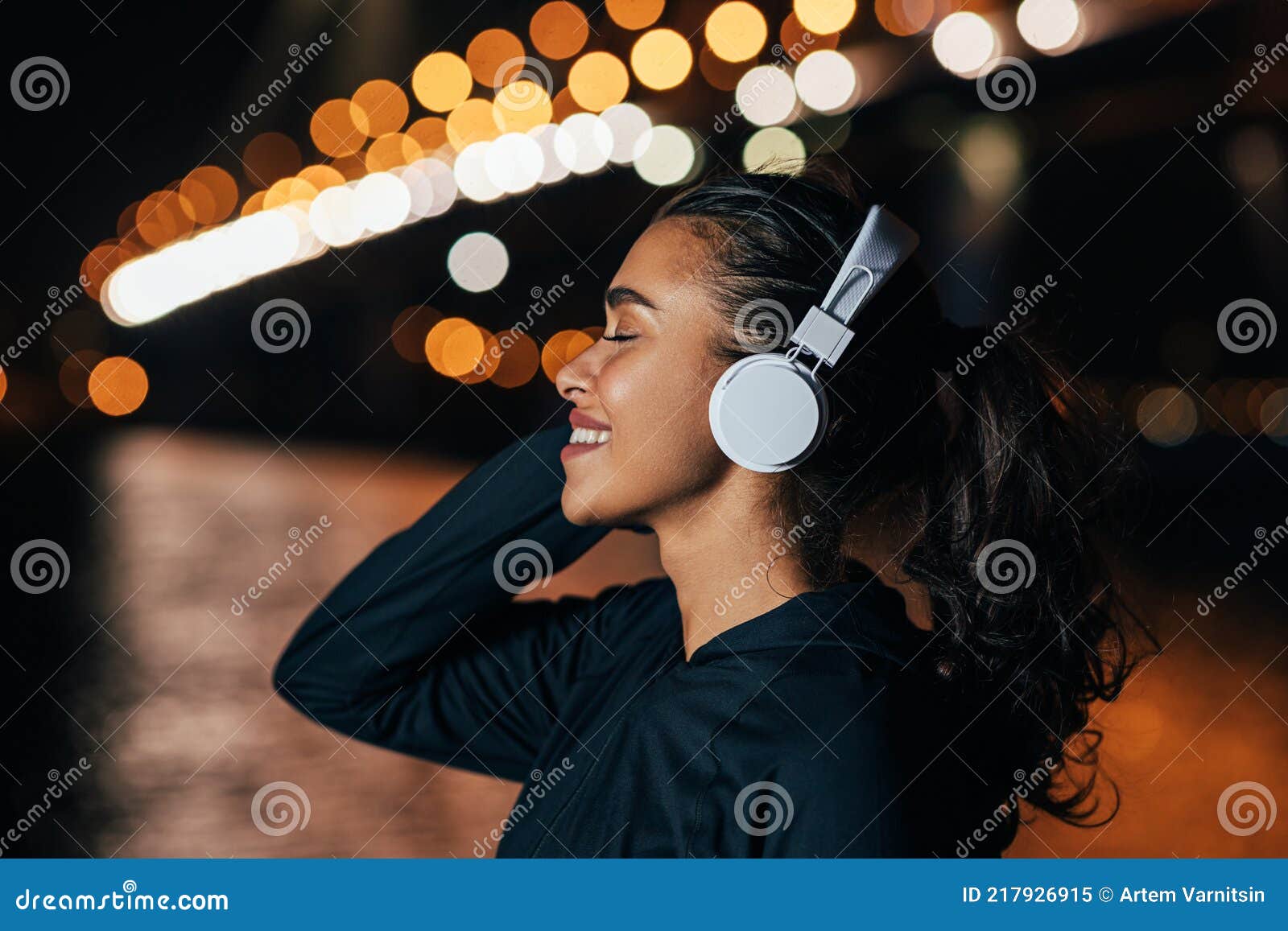 Side View of a Fit Woman in Hooded Shirt Listening To Music Against ... Side View of a Fit Woman in Hooded Shirt Listening To Music Against ...
