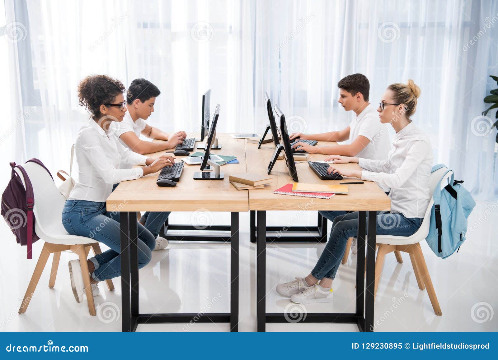 Side View of Four Young Multicultural Students Studying Stock Image ...