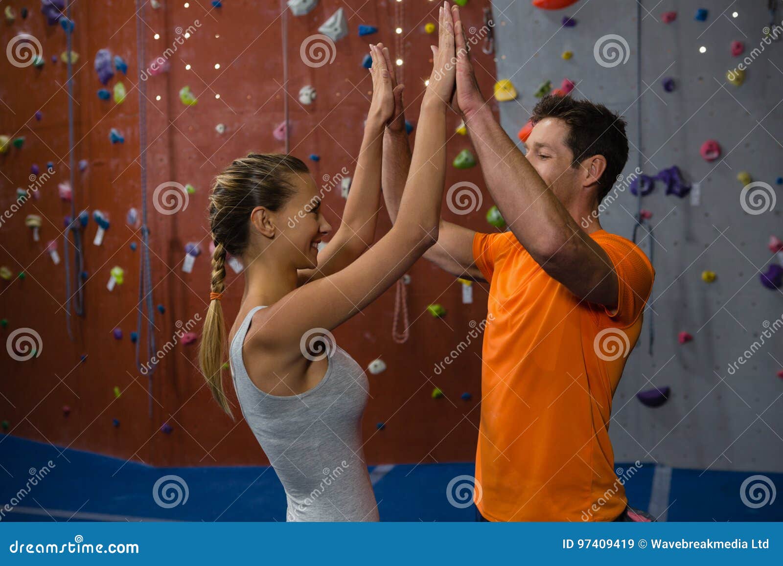 Side View of Friends Giving High Five while Standing by Climbing Wall ...