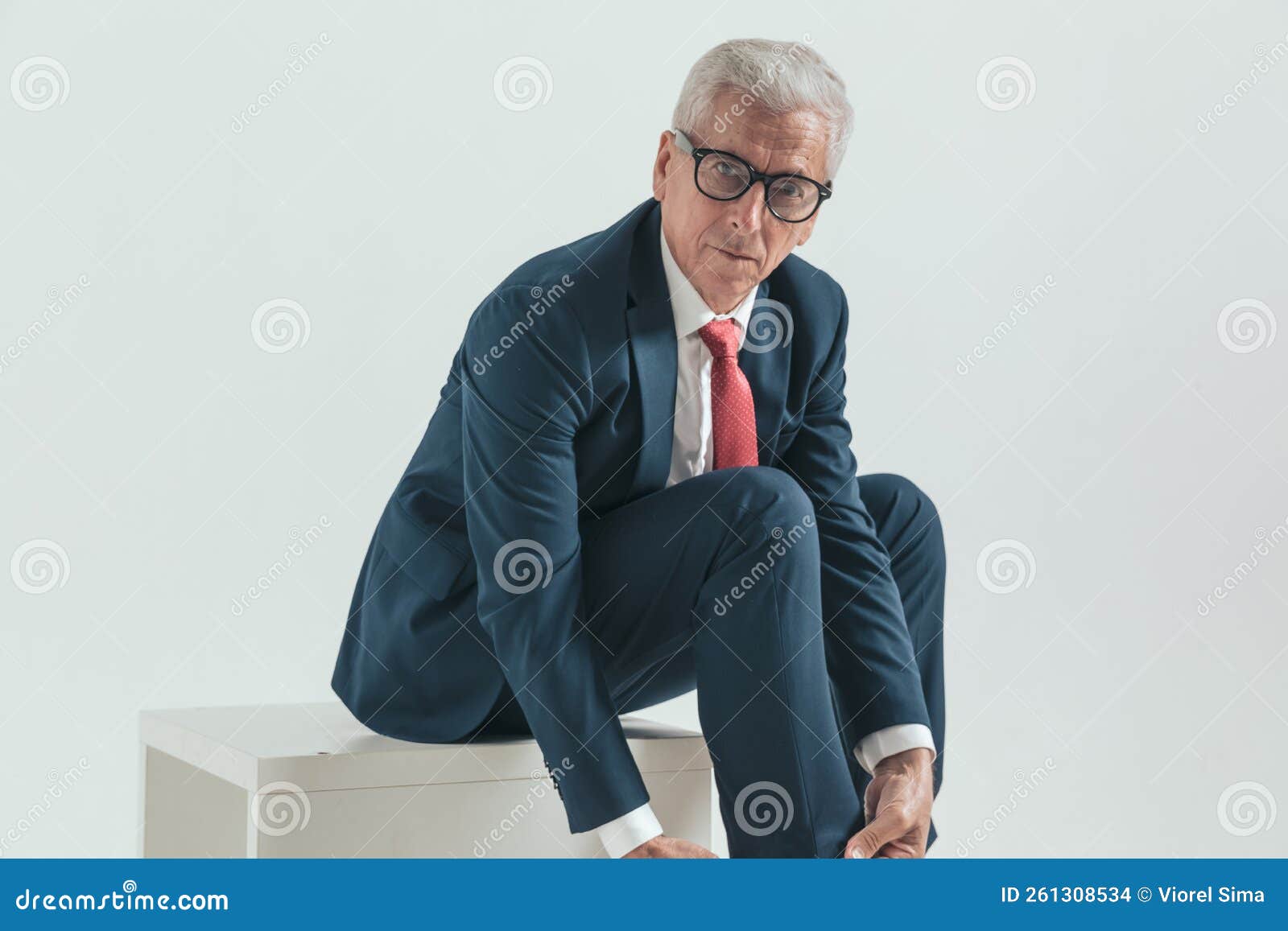Side View of Good Looking Old Man Sitting and Adjusting Suit Pants ...