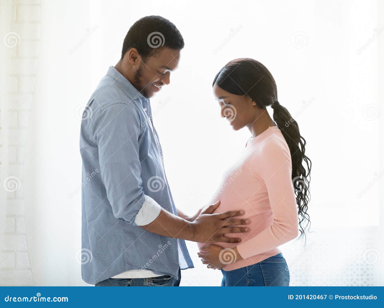 Side View Of Handsome Black Man Touching His Wife`s Pregnant Belly Near