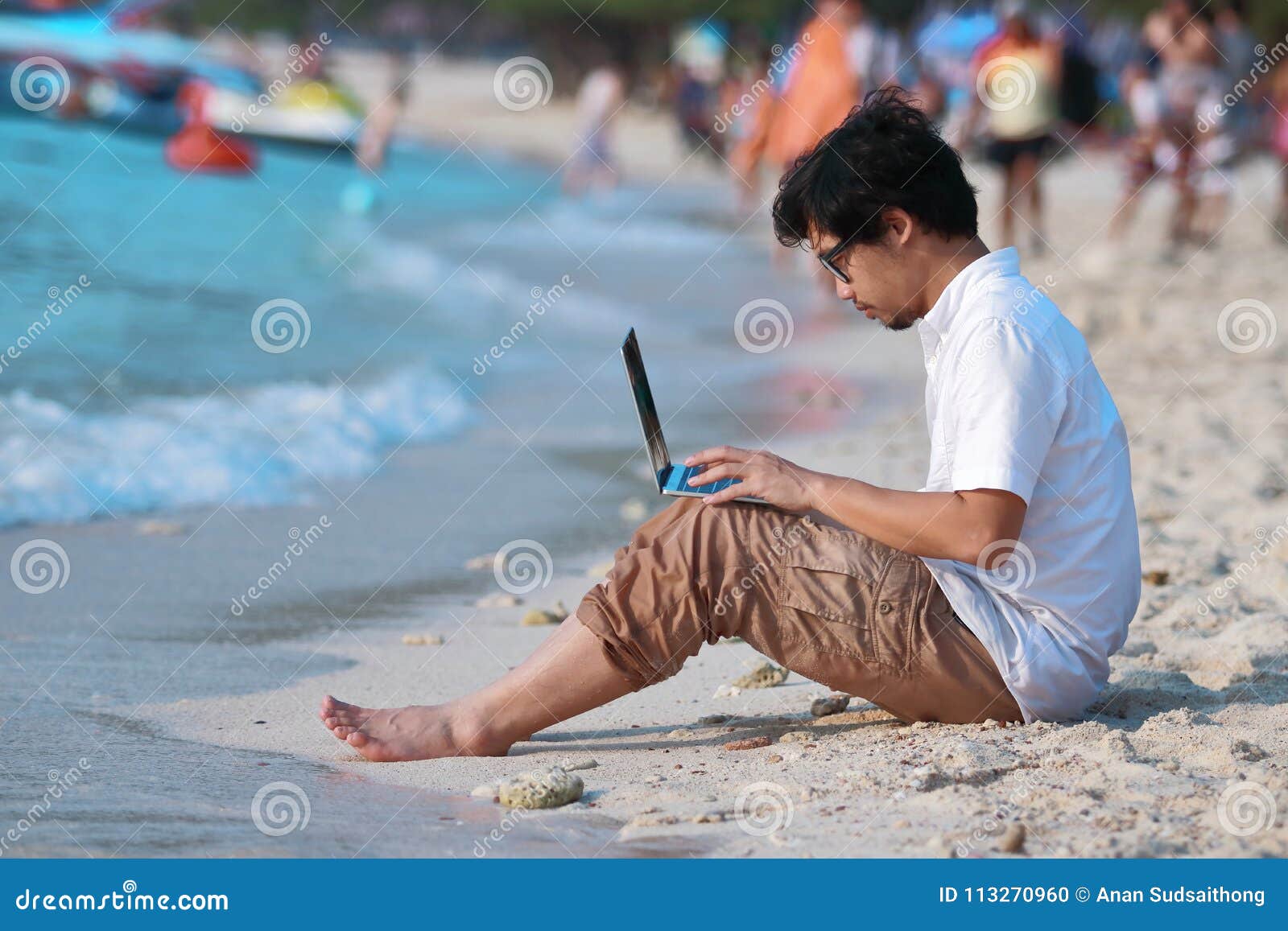 Side View of Handsome Young Asian Man Using Laptop on the Beach. Stock ...