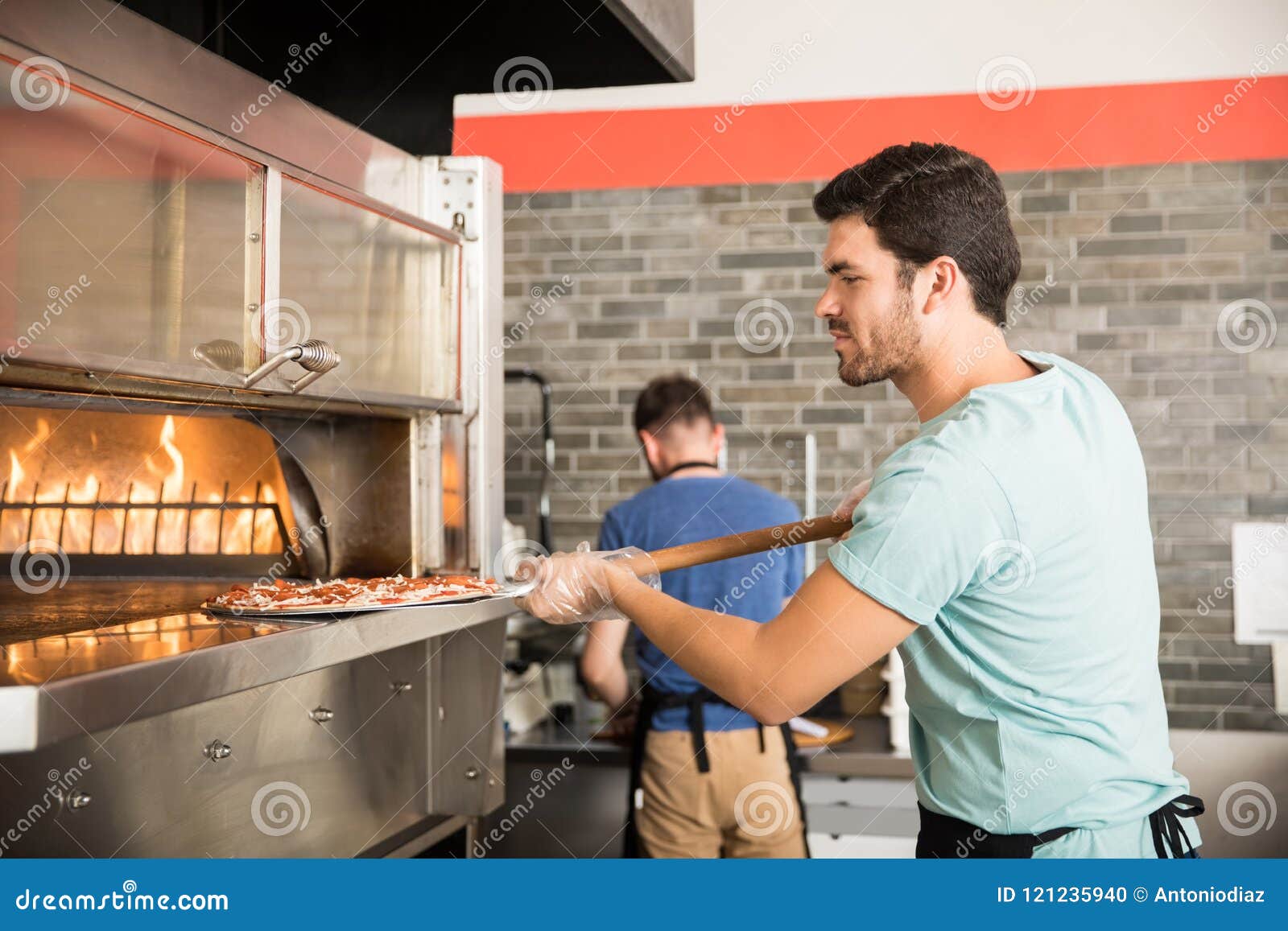 Chef Cooking Pizza and Putting it in the Oven To Bake Stock Photo ...