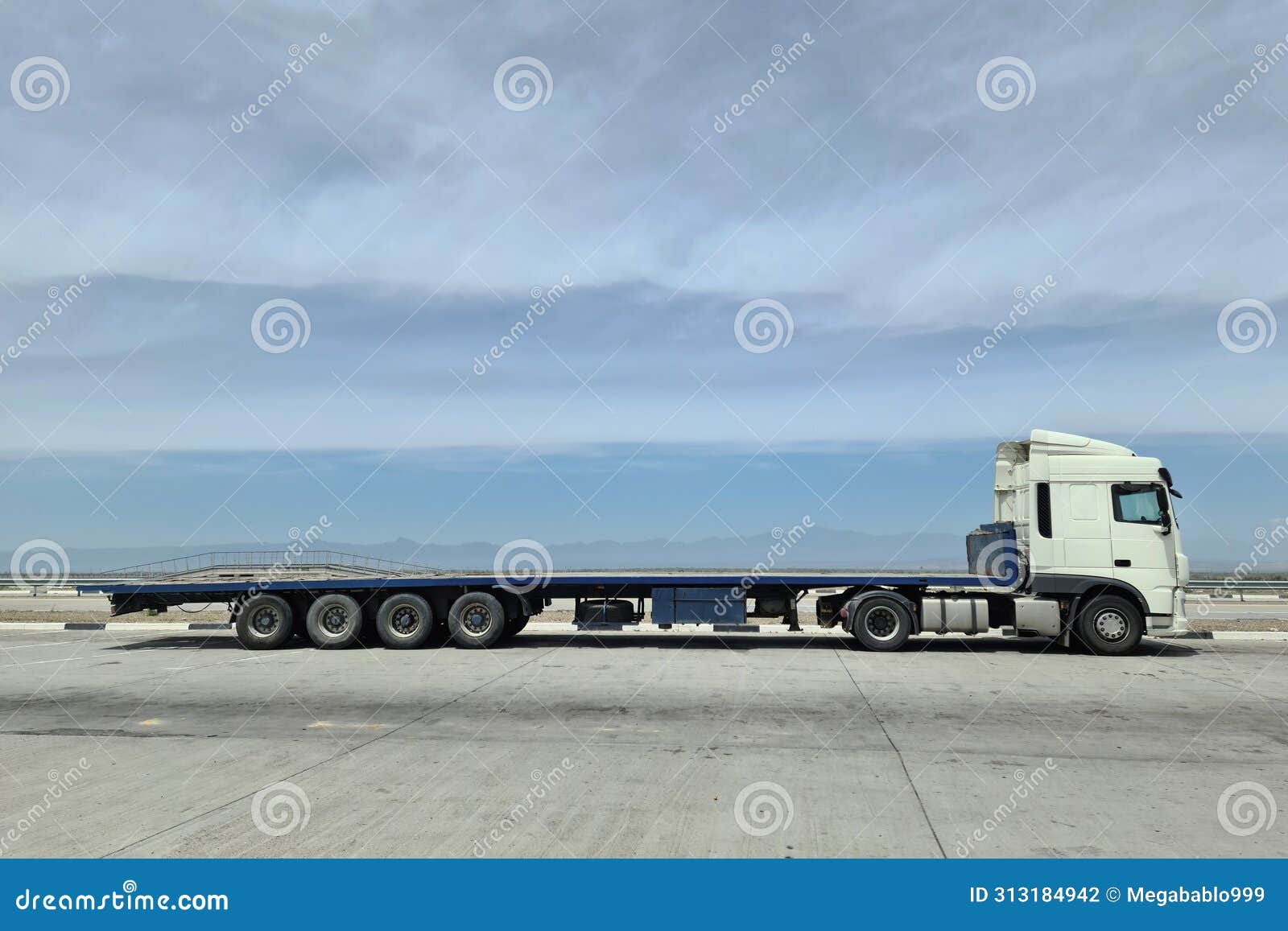 Side View of a Large Length Cargo Big Truck with Copy Space on a Blue ...
