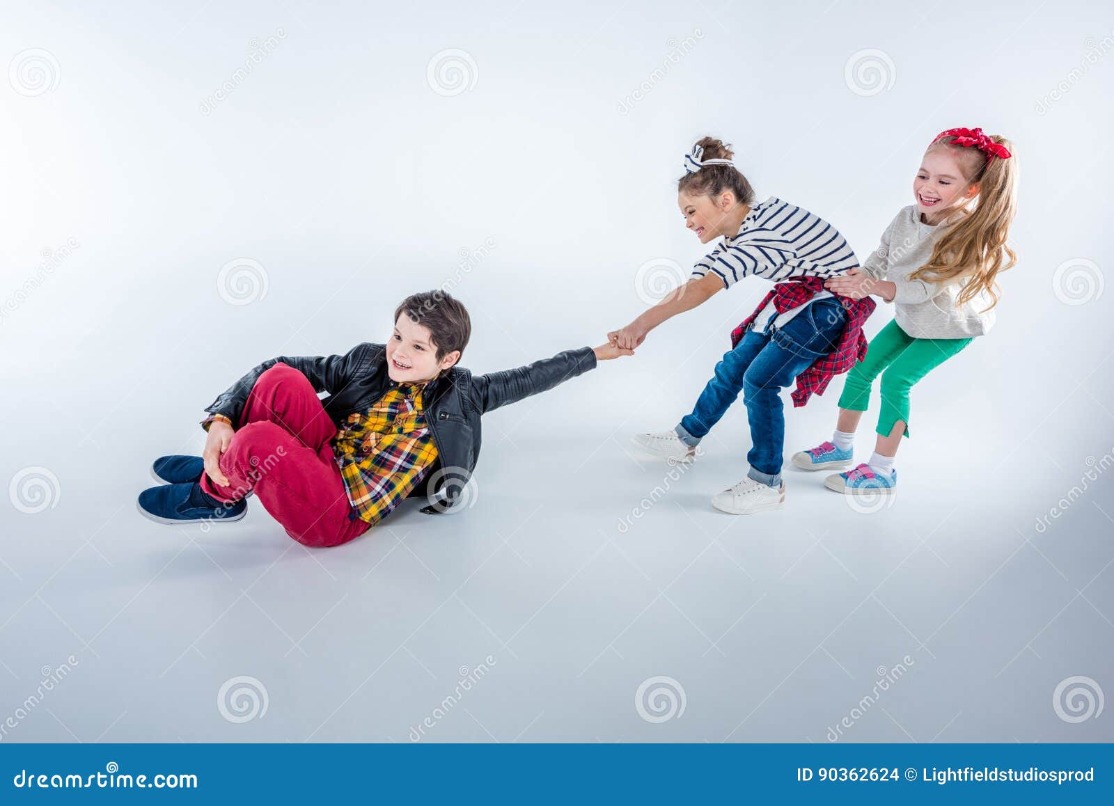 Side View of Laughing Girls Pulling Up Boy Stock Photo - Image of ...