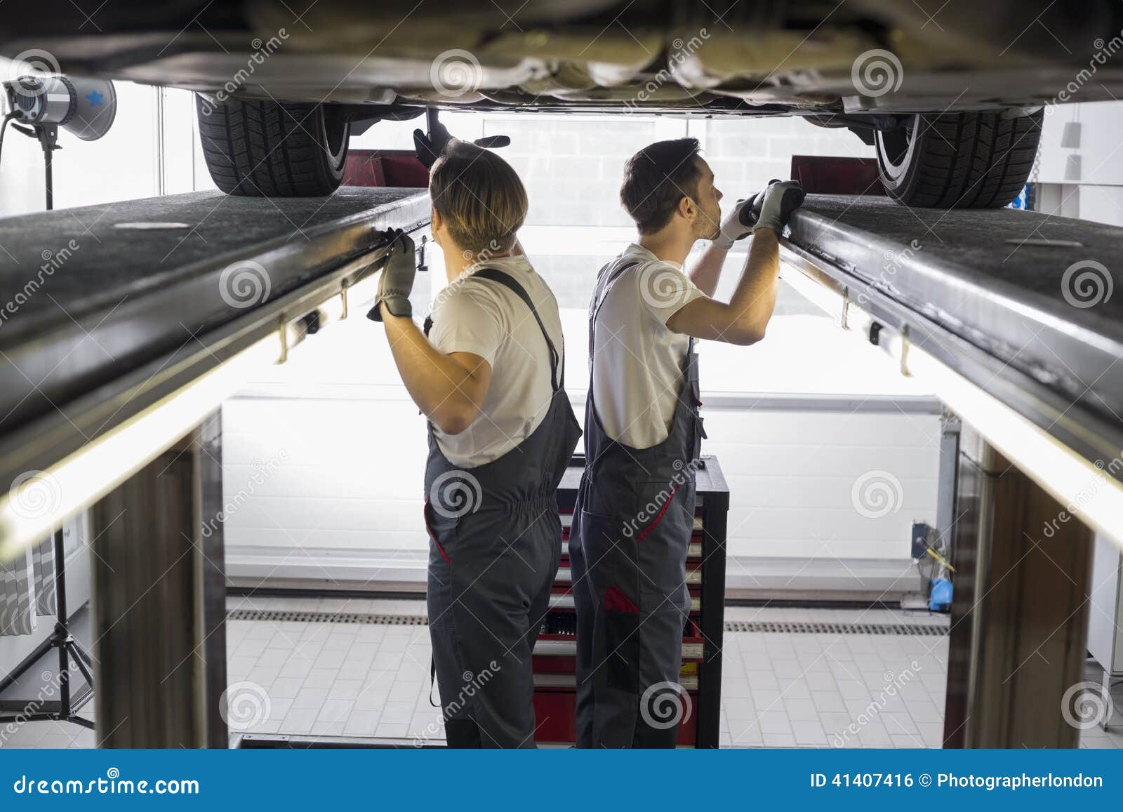 Side View of Maintenance Engineers Examining Car in Repair Shop Stock ...