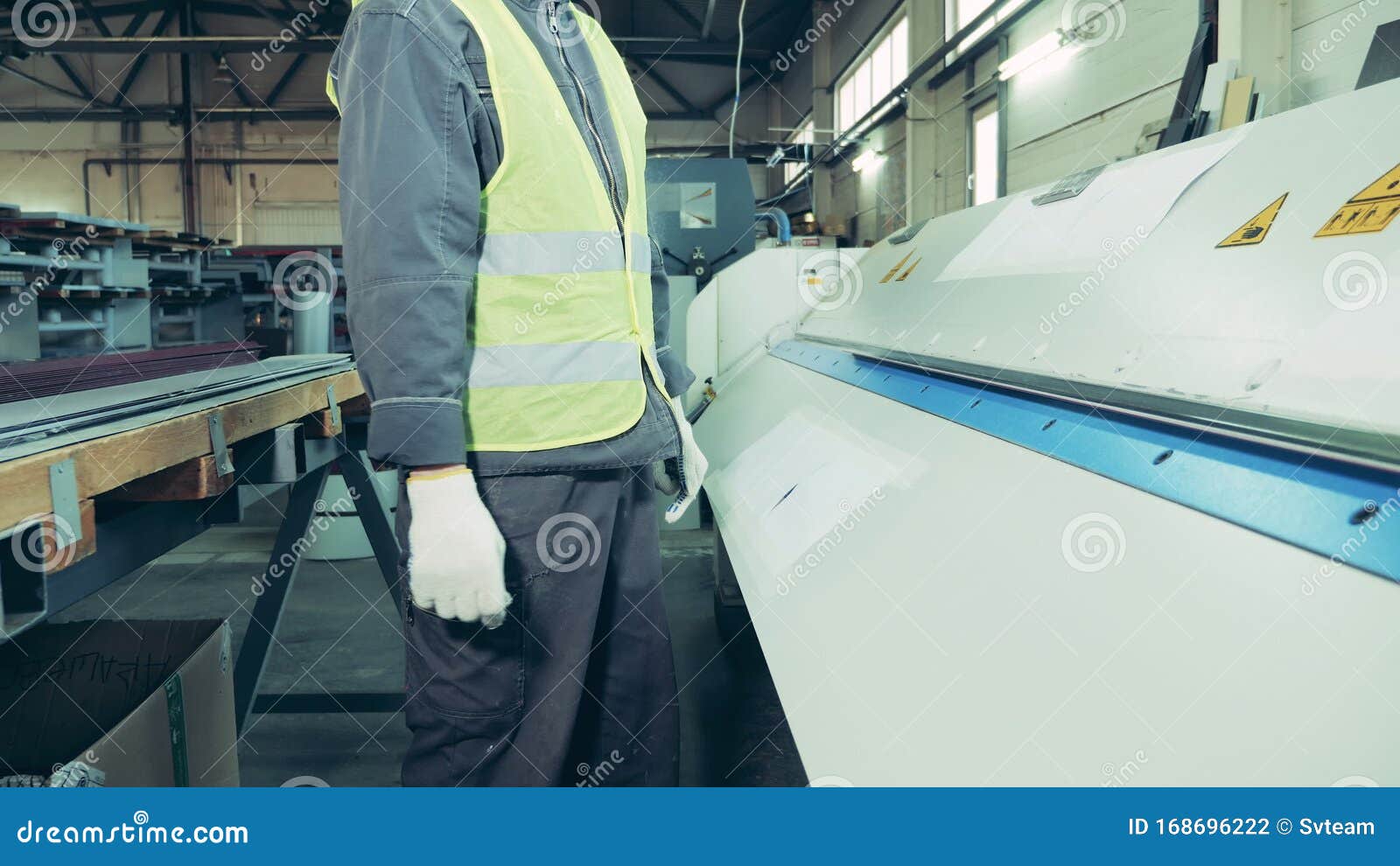 Side View of a Male Worker Loading Metal into the Bending Machine Stock ...