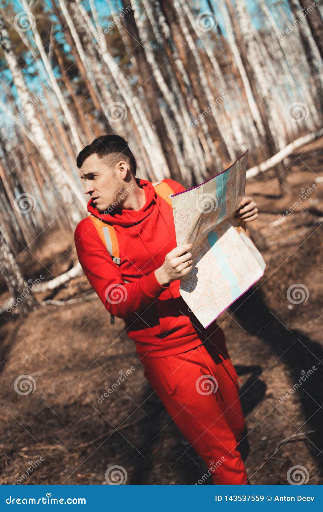 Traveling Man with Map in Woods. Side View of Man with Backpack Reading ...