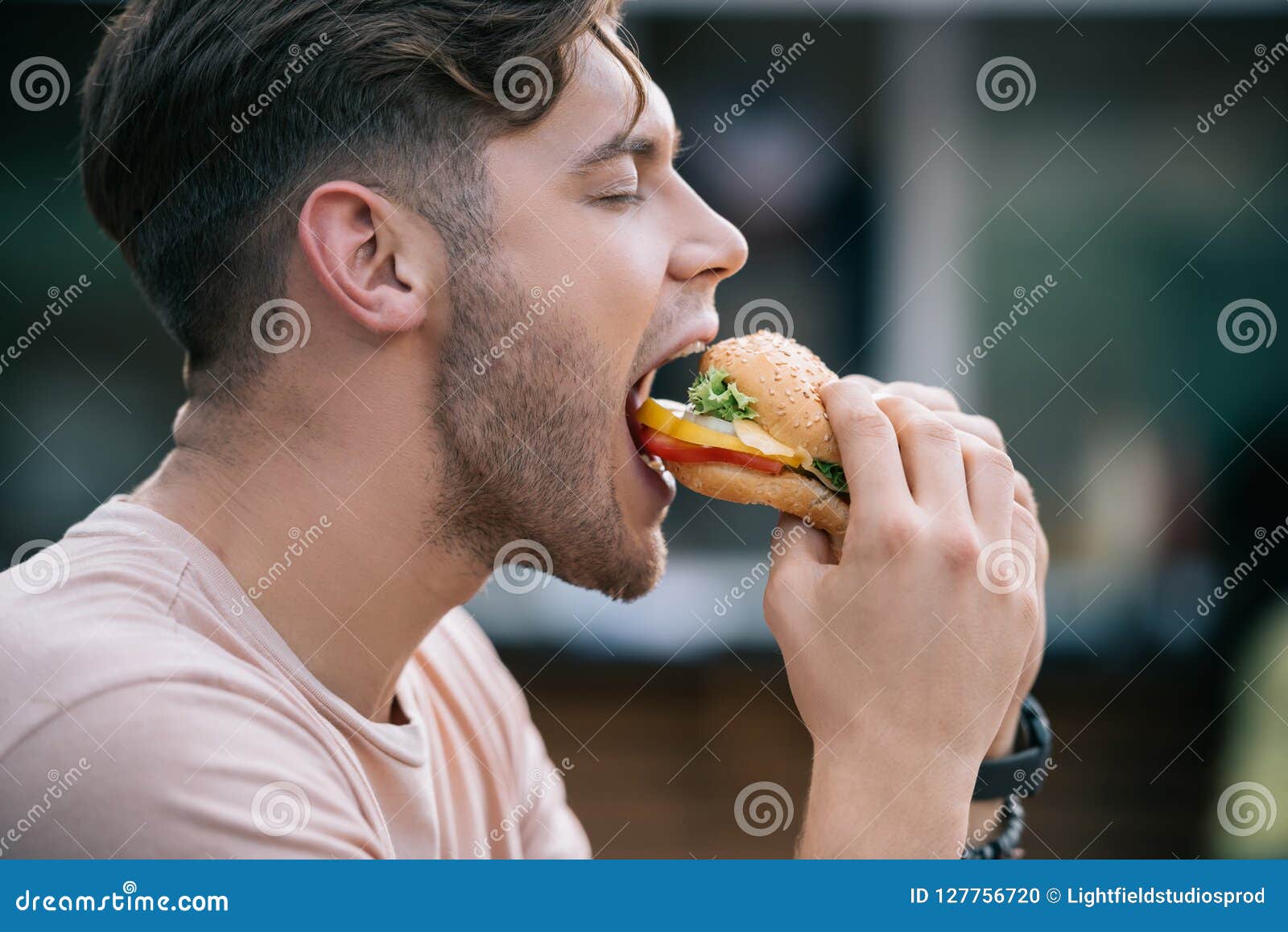 Side View of Man Eating Tasty Burger Stock Photo - Image of urban ...
