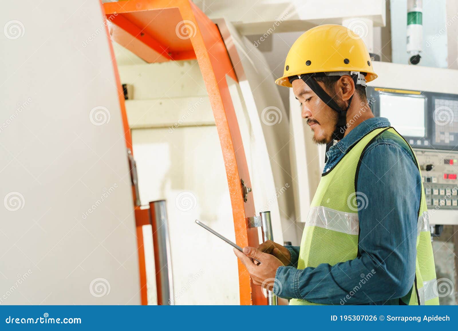 Side View of Man Engineer Working on Machine and Check with Tablet ...