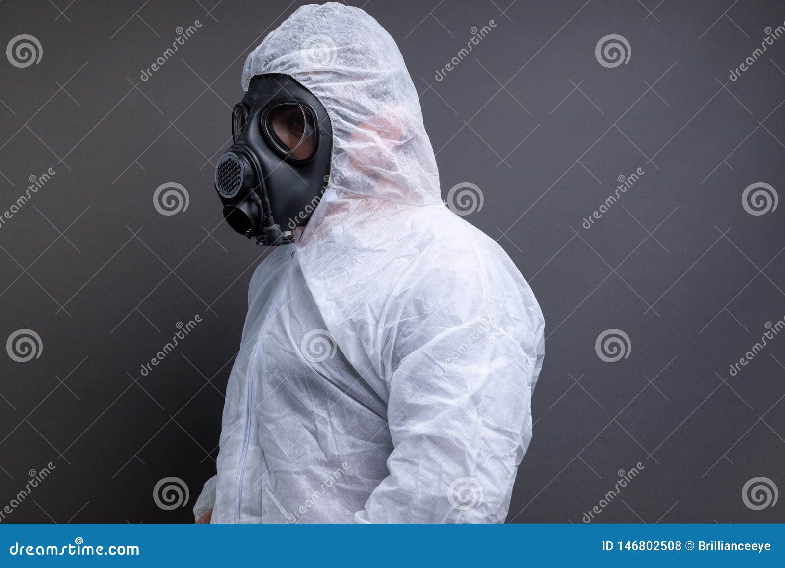 Side View of Man with Gas Mask in Protective Overall Suit Against Grey ...
