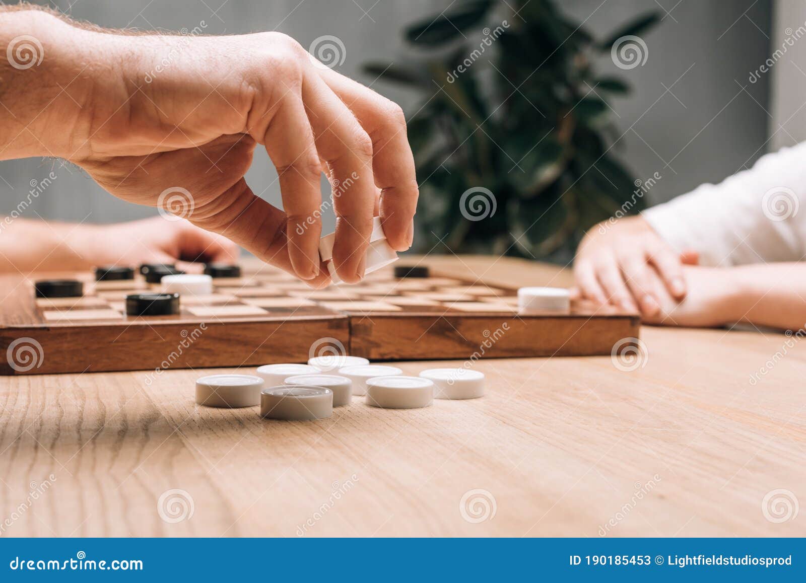Side View of Man Holding White Checkers while Playing with Woman Stock ...