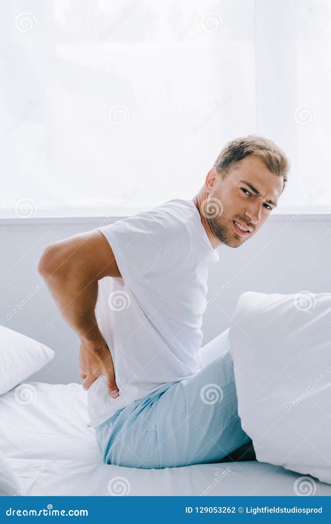 Side View of Man Suffering from Back Pain and Looking at Camera Stock ...