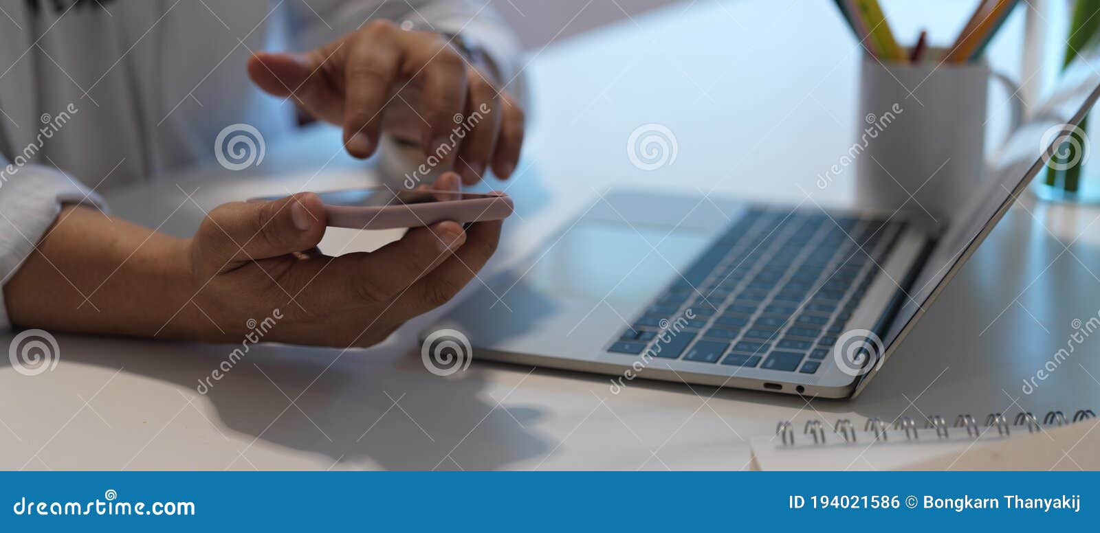 Side View of a Man Using Smartphone while Working with Laptop on ...