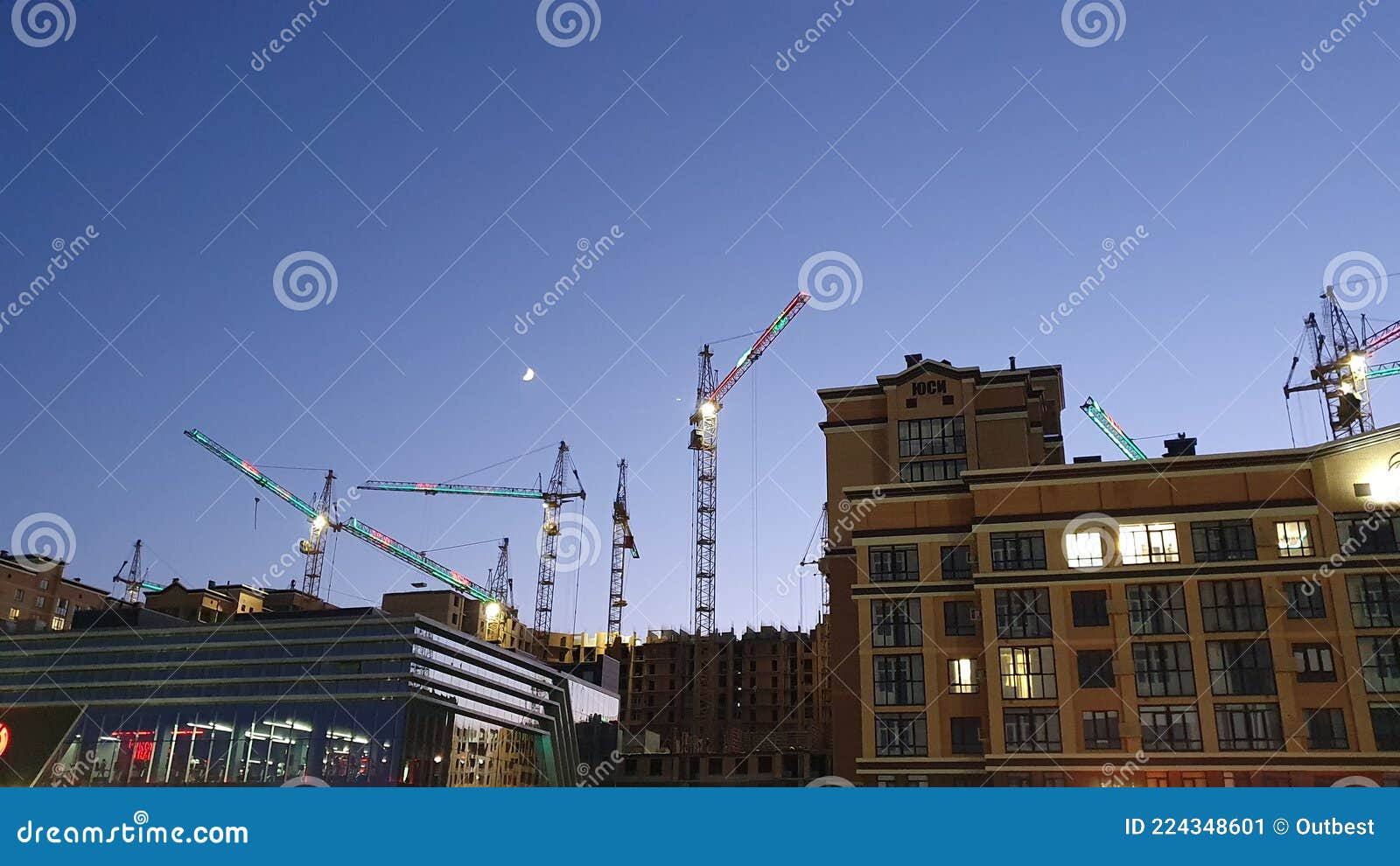 A Side View of a Modern Buildings with Construction Cranes on the ...