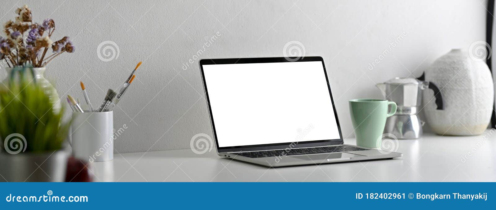 Side View of Modern Office Desk with Blank Screen Laptop, Painting ...