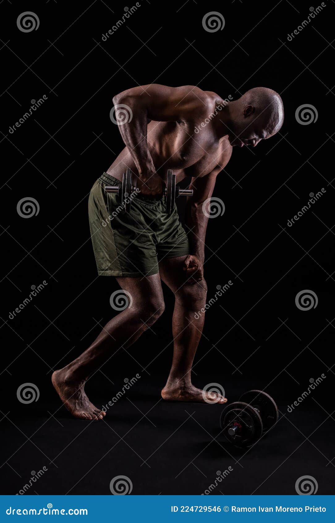 Side View of a Muscular Man Standing Leaning Forward Doing Triceps ...