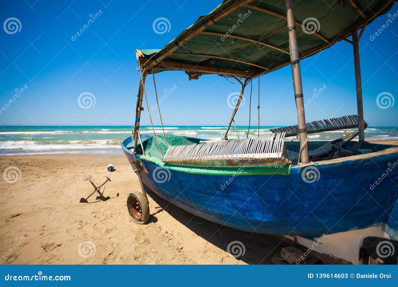 A Side View of an Old Fishing Boat on the Beach with an Anchor on Its ...