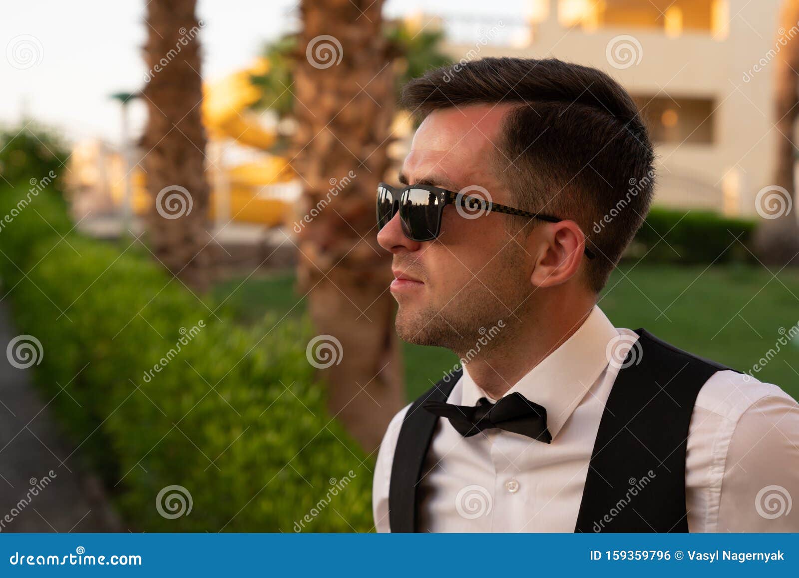 Side View Portrait Of The Attractive Young Man In White Shirt And