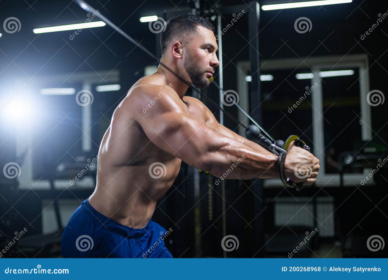 Side View Portrait of a Bodybuilder Working on His Chest Muscles with ...