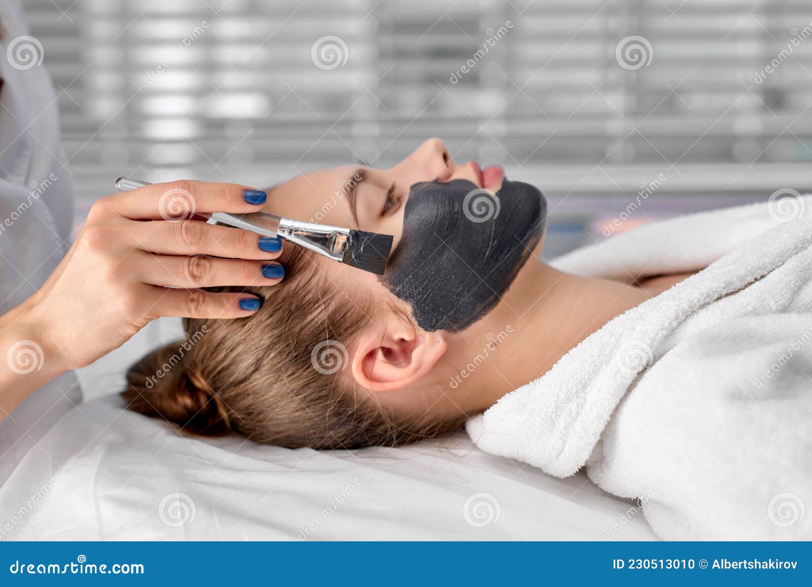 Side View Portrait Of Calm Good Looking Young Woman Enjoying Spa Lying On Massage Table Stock