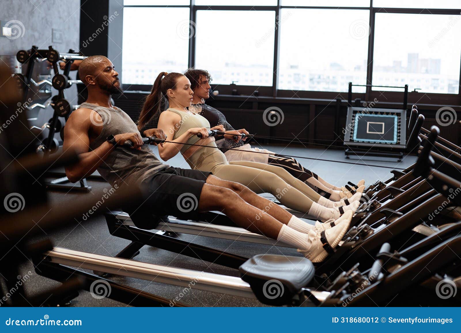 People Using Rowing Machine in Gym Stock Photo - Image of people ...