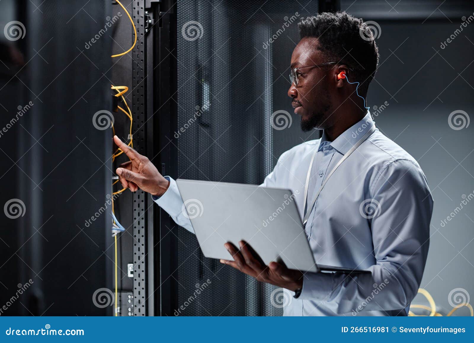 Young Network Engineer Working with Servers in Data Center and Holding ...