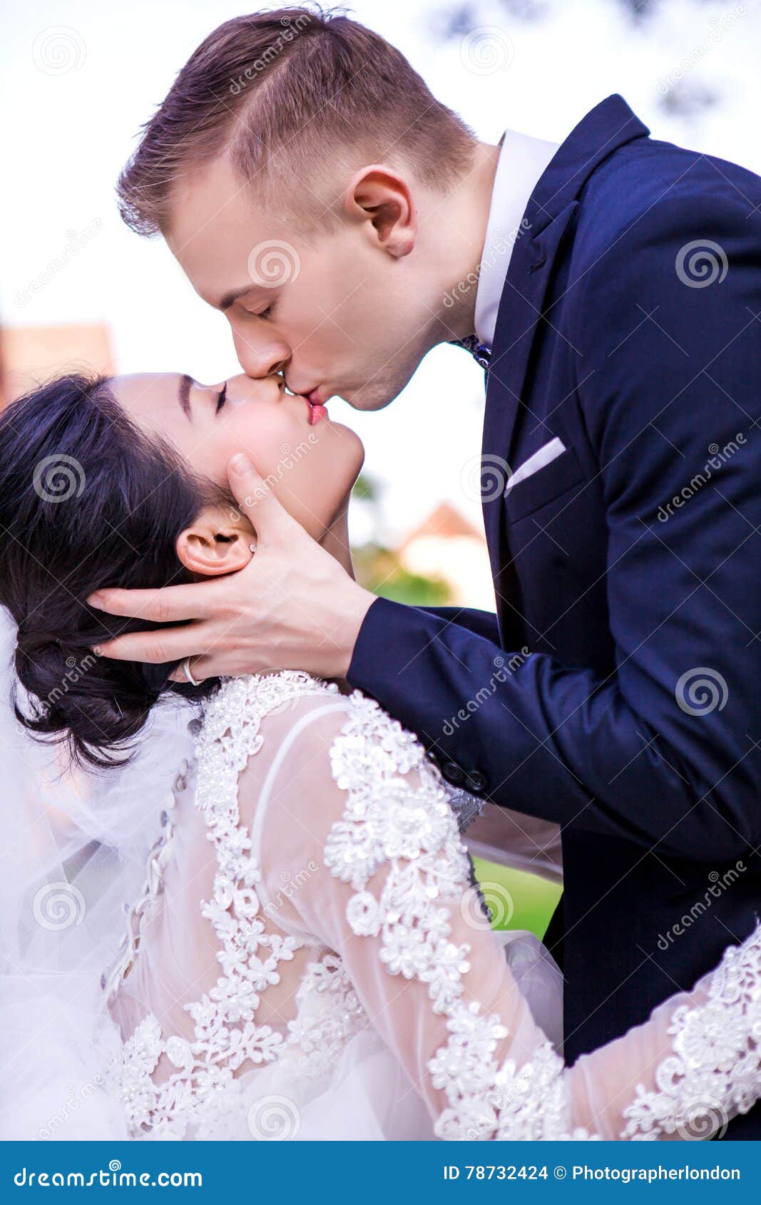 Side View of Romantic Wedding Couple Kissing Against Sky Stock Photo ...