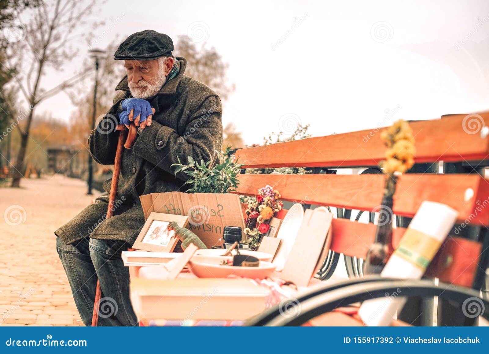 Side View of a Sad Poor Man Sitting on Bench Selling Stuff Stock Photo ...