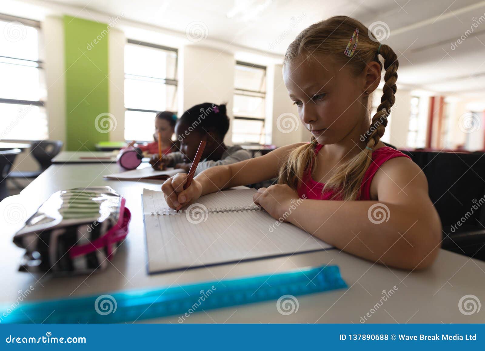 Side View of Schoolgirl Studying at Desk in Classroom Stock Photo ...