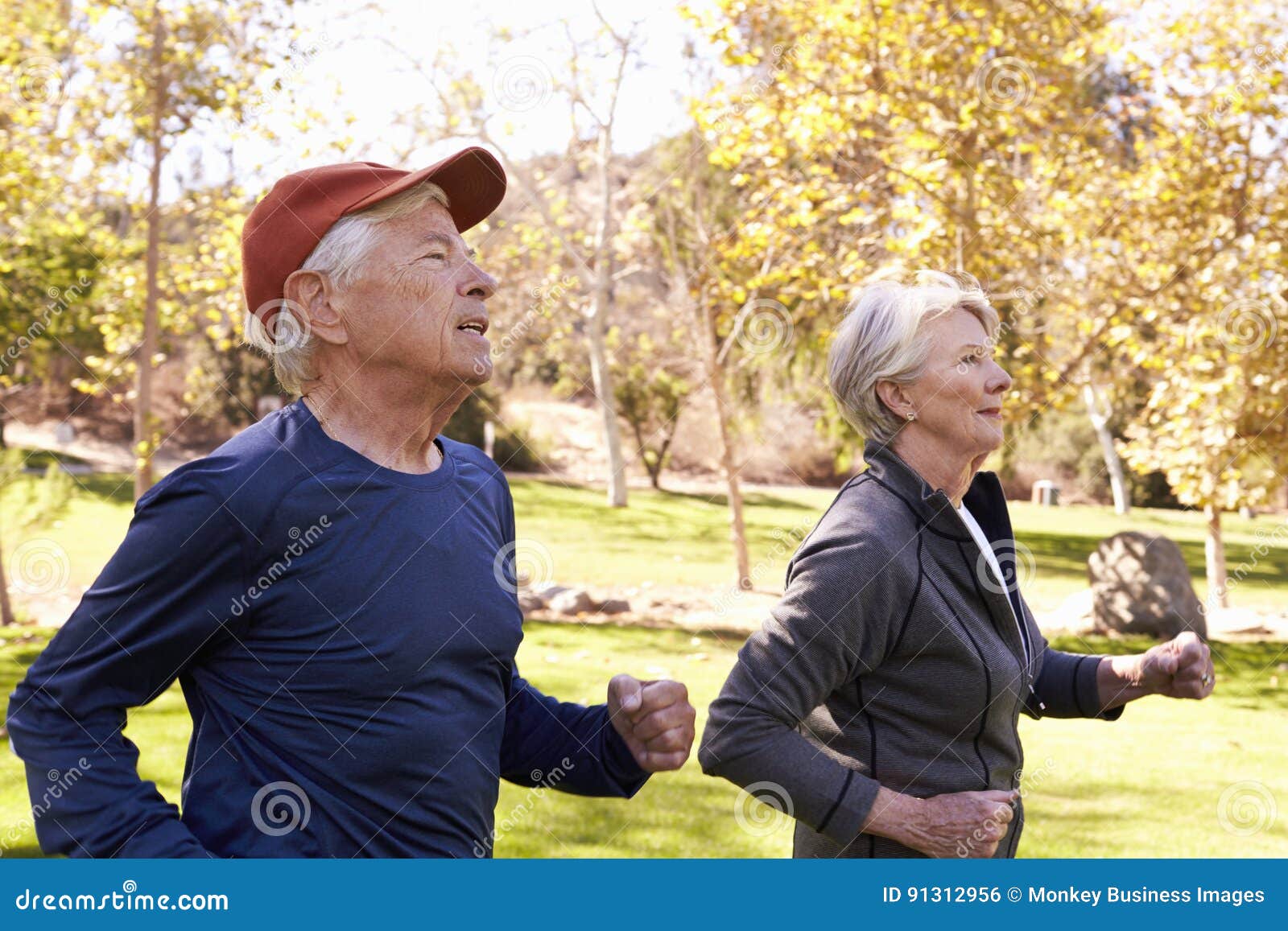 Side View of Senior Couple Power Walking through Park Stock Photo ...