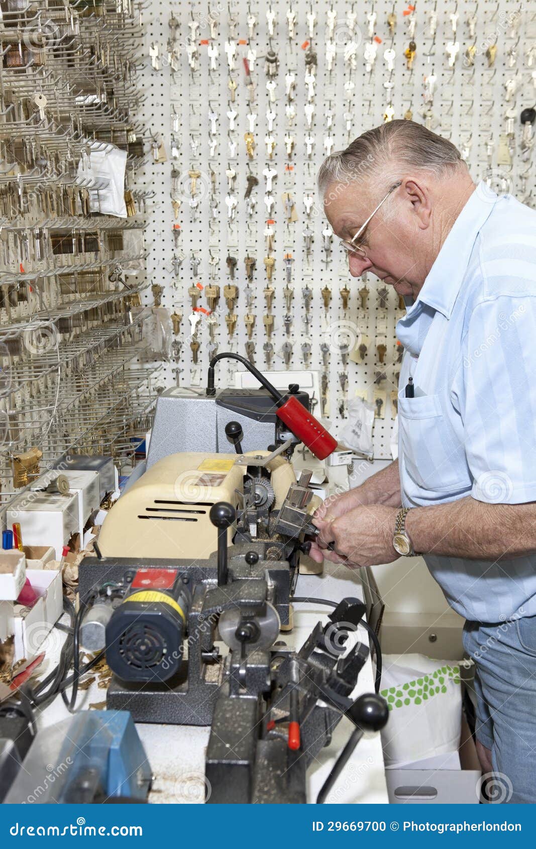 Side View of Senior Locksmith Making Key in Store Stock Photo - Image ...