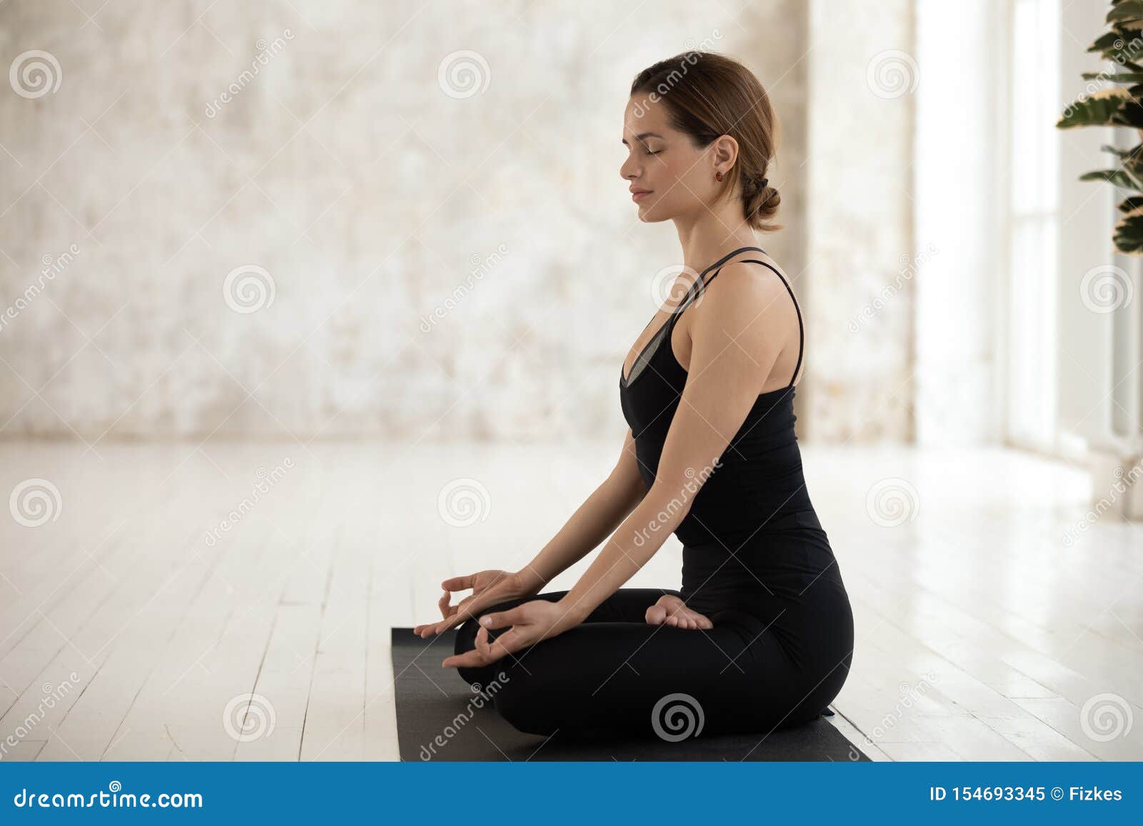Side View Serene Woman Sitting In Lotus Position Meditating Indoors