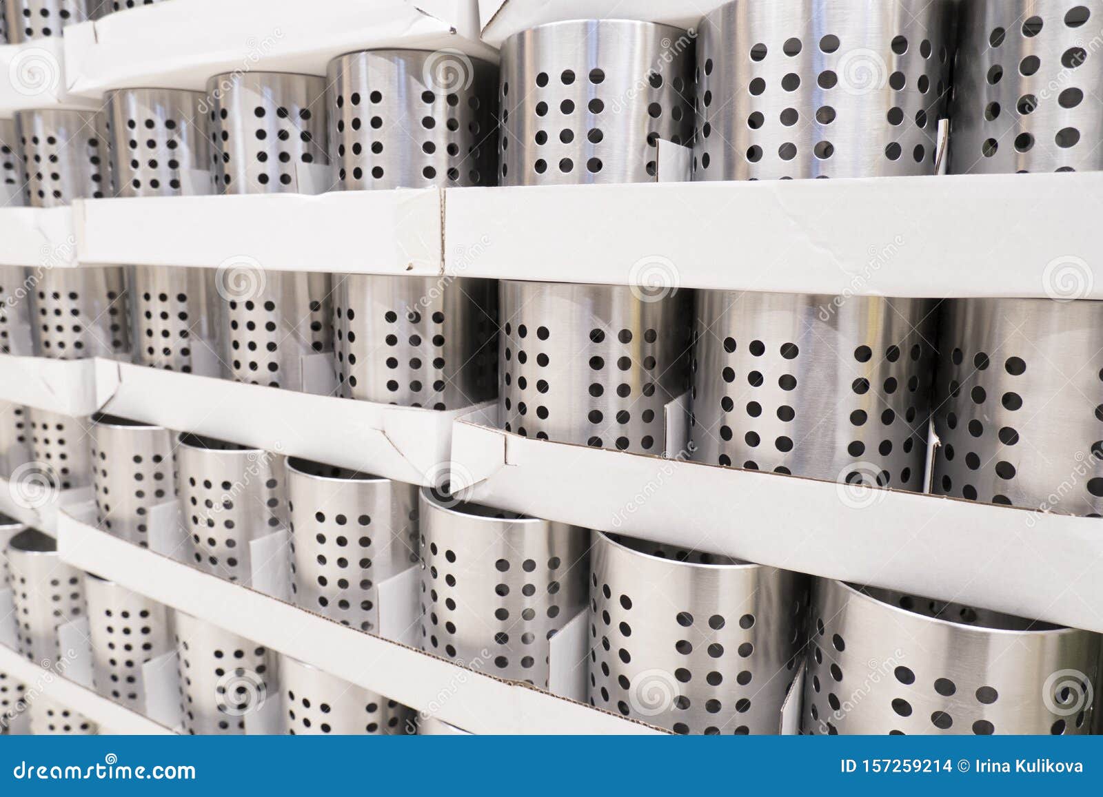 Several Rows of Metal Containers with Holes in Cardboard Packaging on a ...