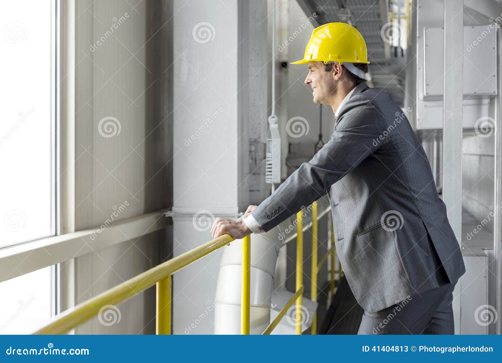 Side View of Smiling Male Architect Leaning on Railing in Industry ...