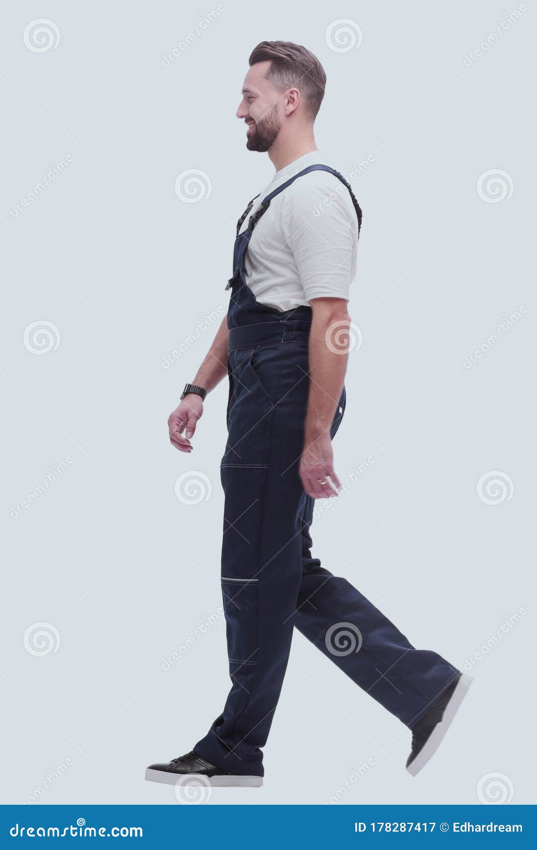 Side View. Smiling Man in Overalls Confidently Striding Forward Stock ...
