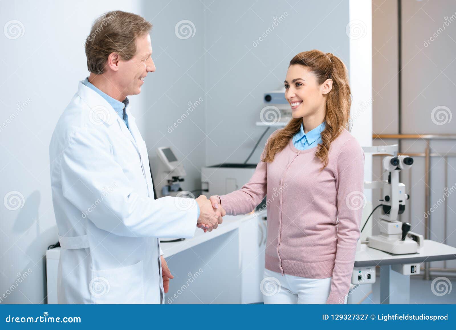 Side View of Smiling Ophthalmologist and Patient Shaking Hands Stock ...