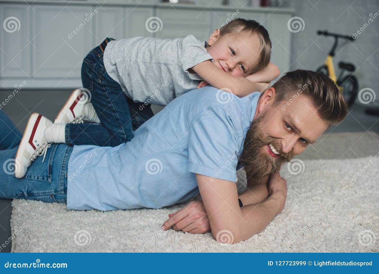 Side View of Smiling Son Lying on Fathers Back Stock Image - Image of ...