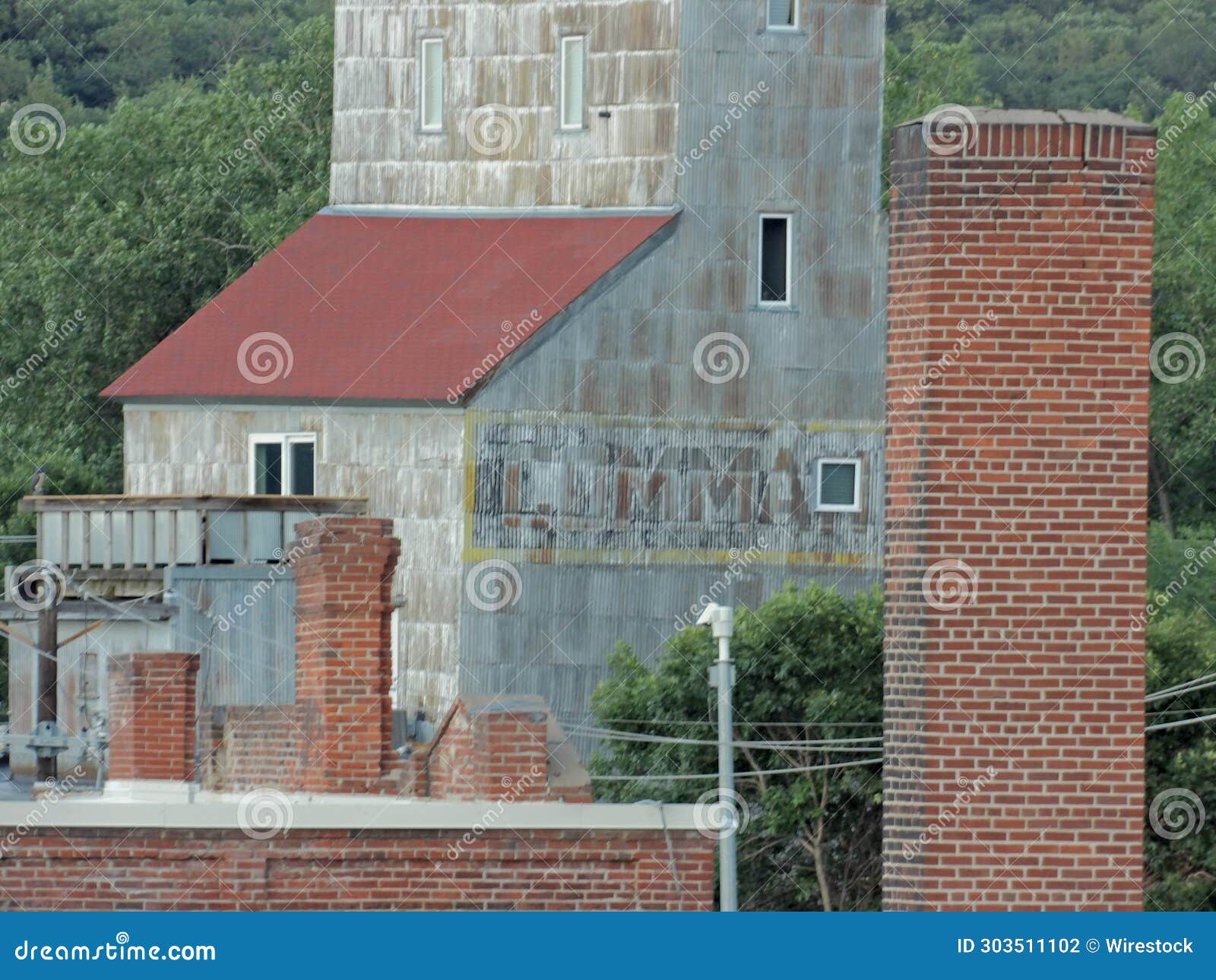 Side View of a Tall Cement Silo Situated beside Two Brick Pillars and a ...