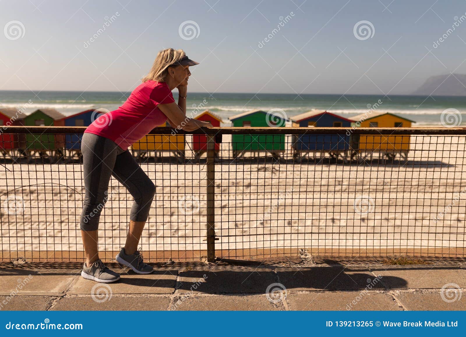 Senior Woman Leaning on a Railing at Beach Stock Image - Image of ...
