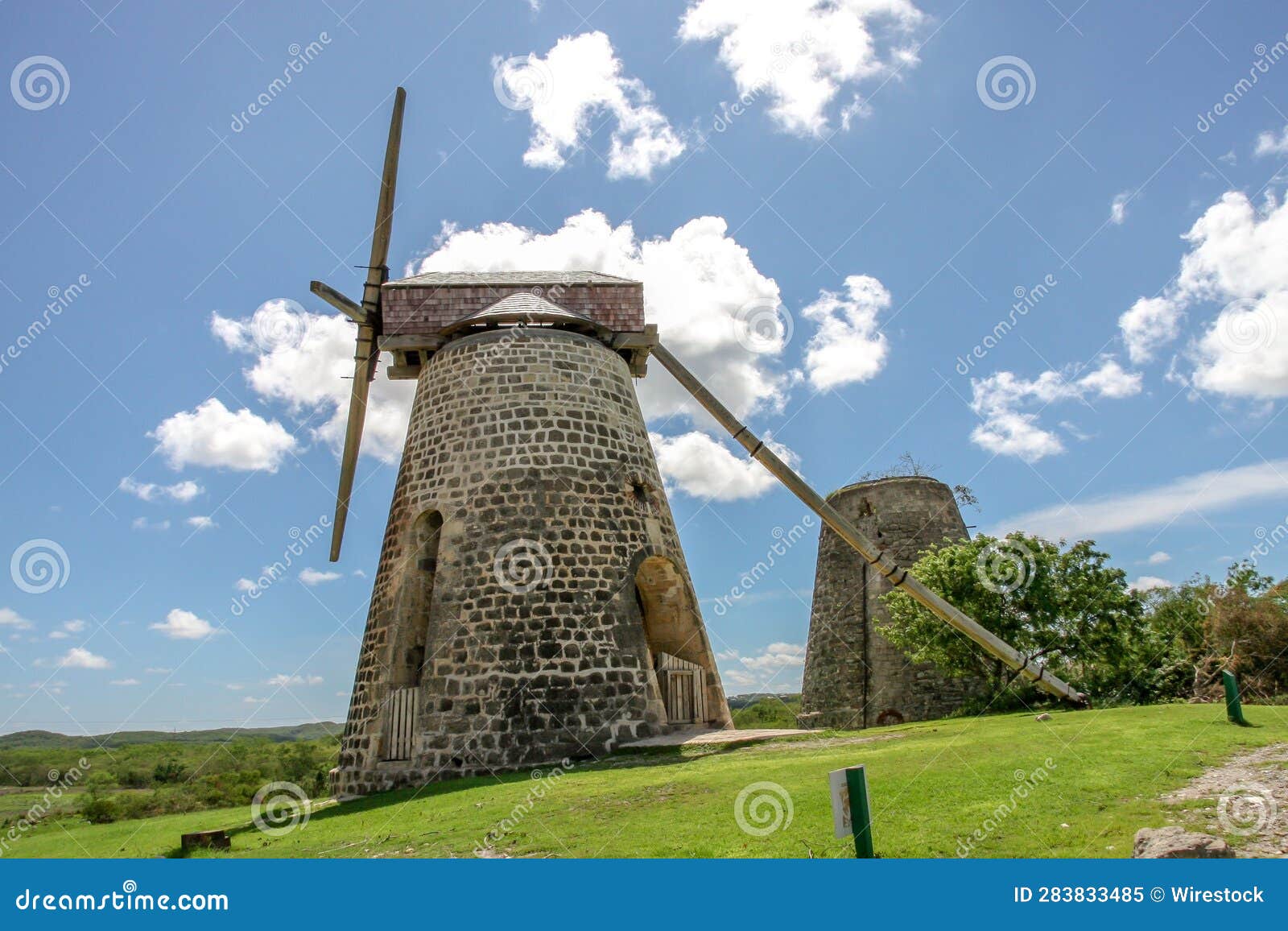 Side View of Two Rustic, Brick Windmills in a Green Field Stock Image ...