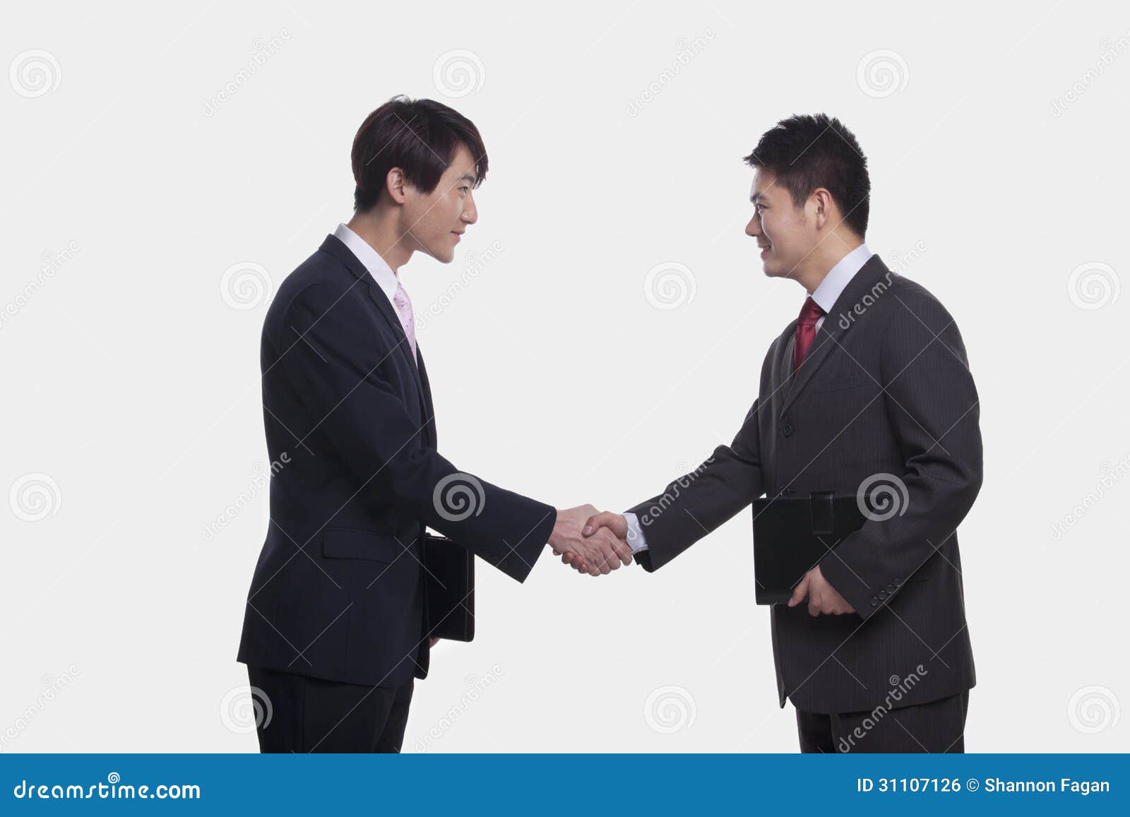Side View of Two Smiling Businessmen Shaking Hands, Studio Shot Stock ...