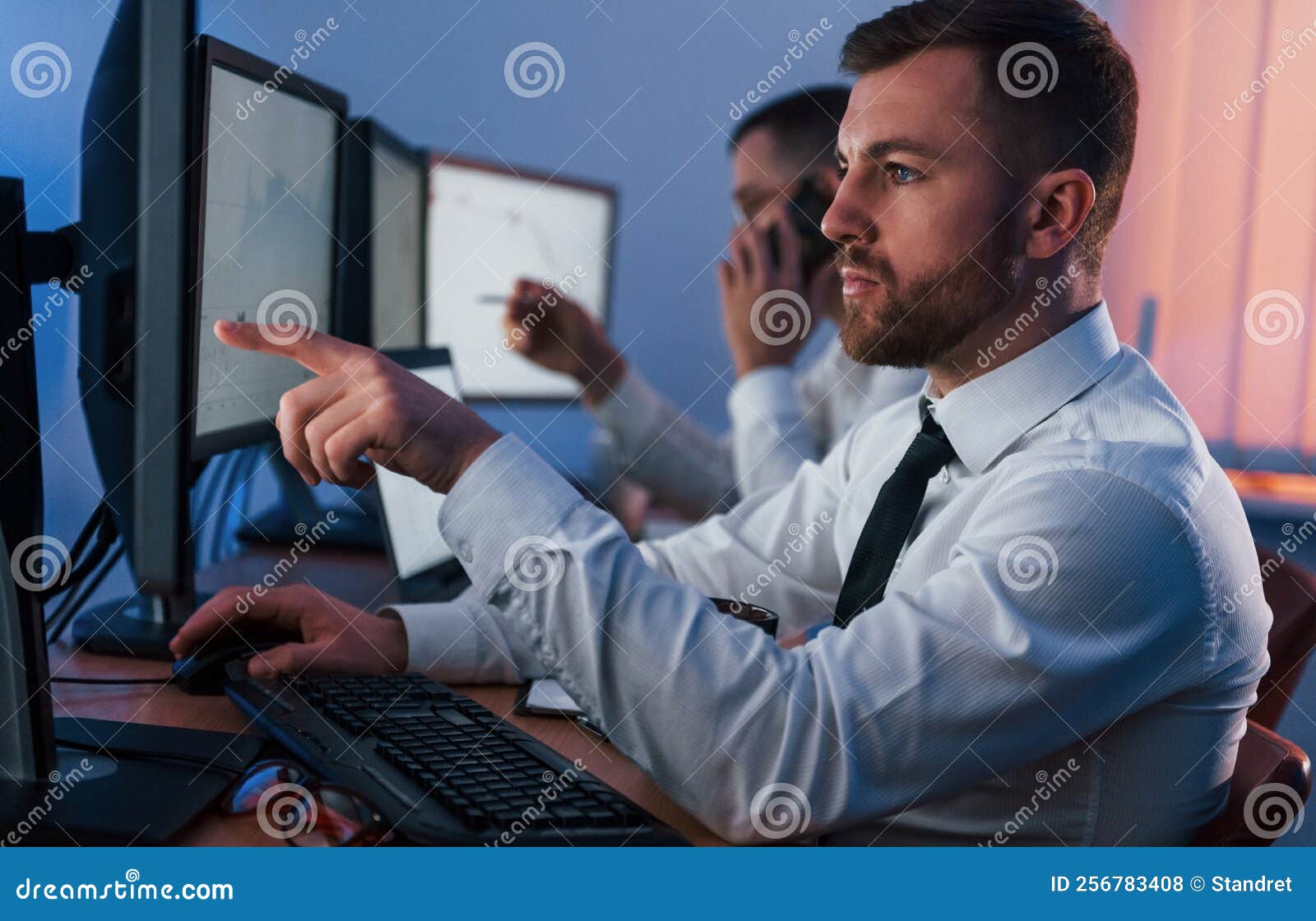 Side View. Two Stock Traders Working in the Office with Exchange ...