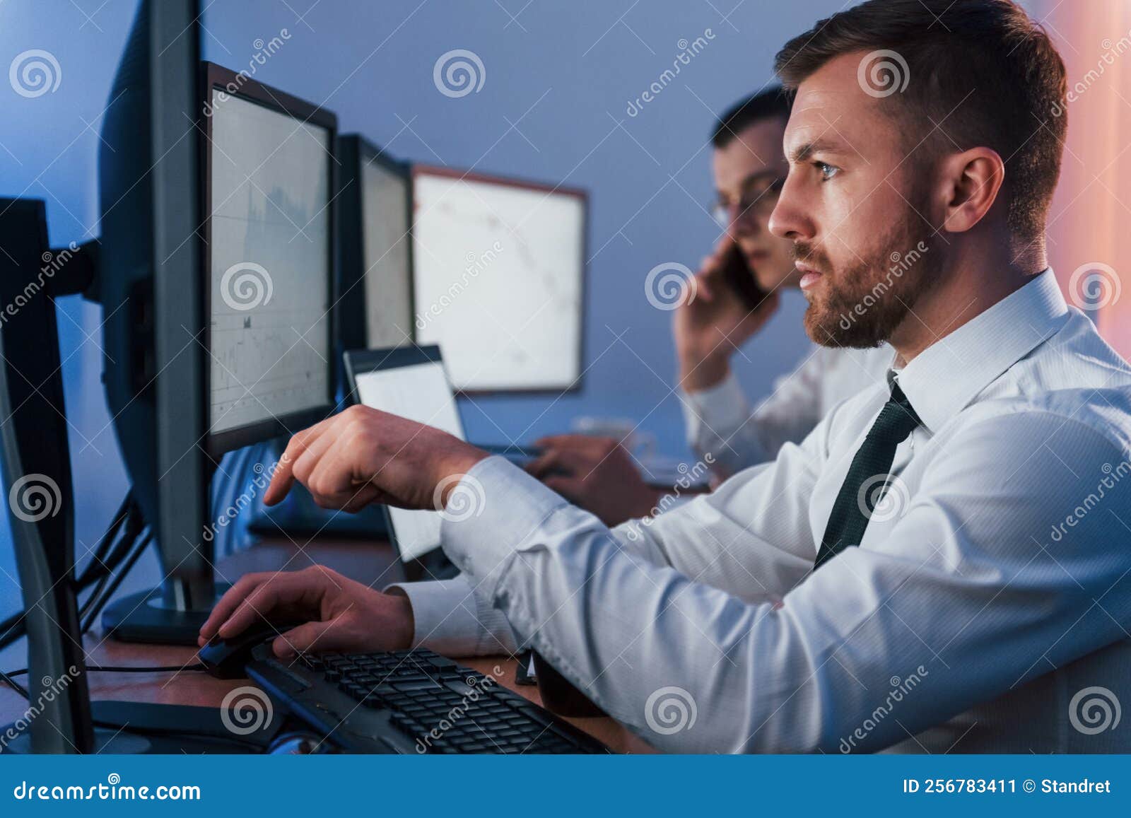 Side View. Two Stock Traders Working in the Office with Exchange ...