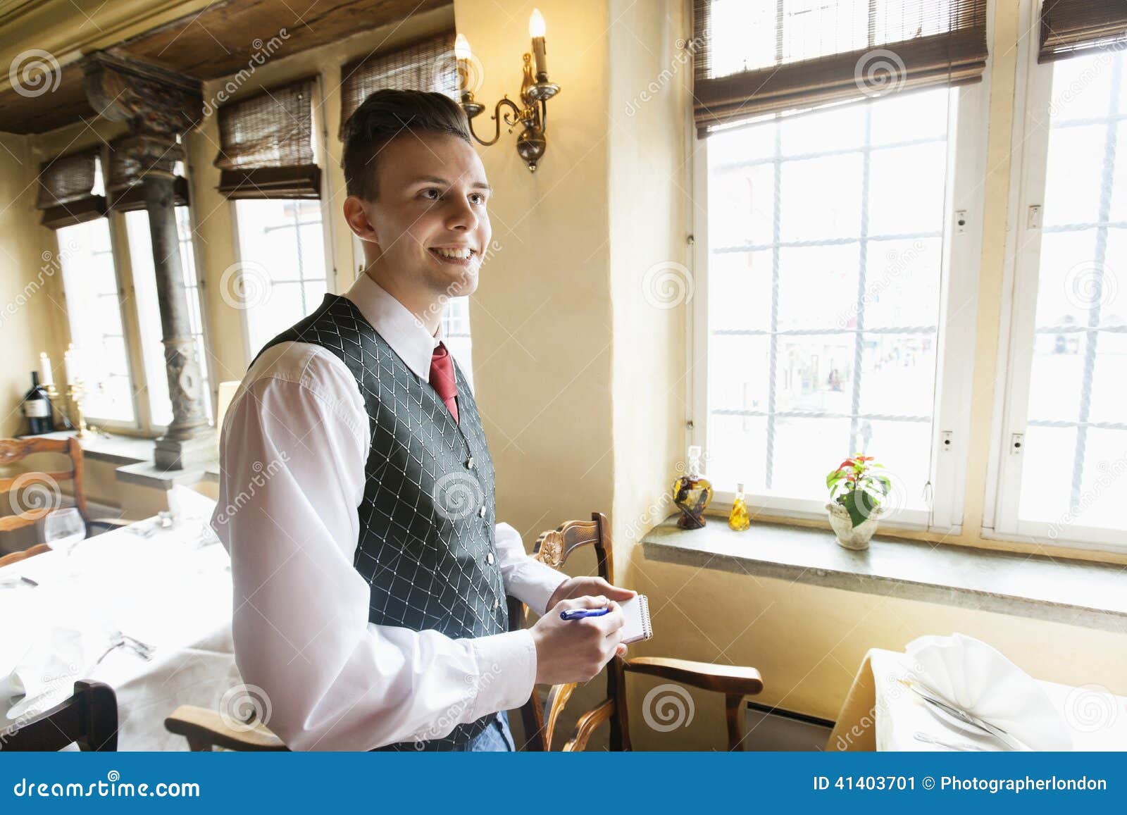 Side View of Waiter with Notepad Smiling in Restaurant Stock Image ...
