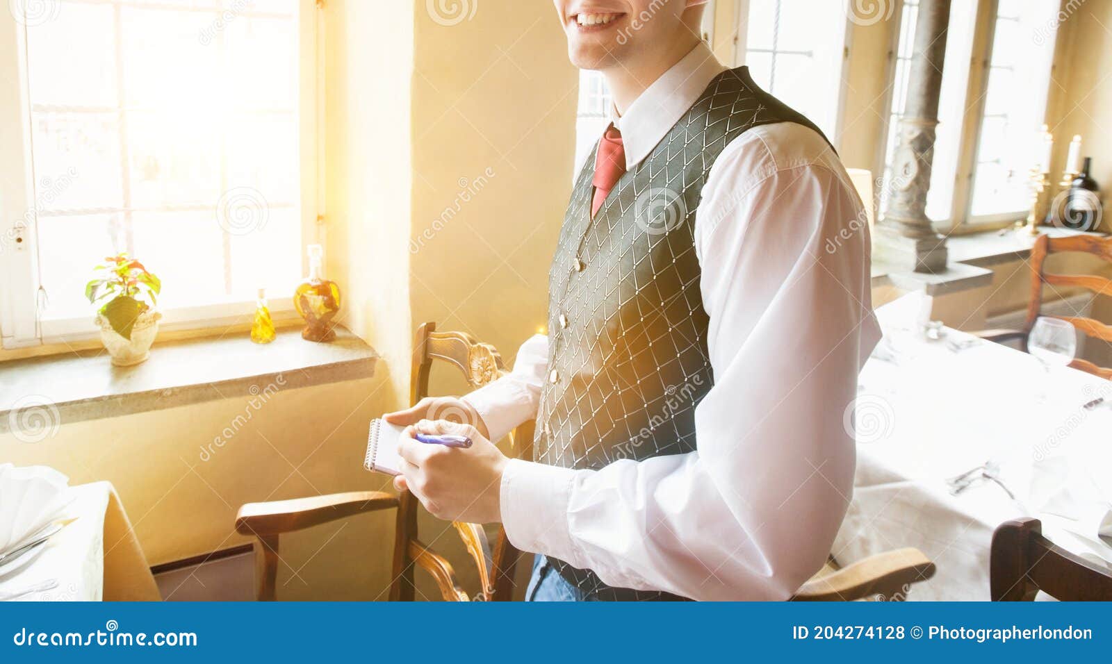 Side View of Waiter with Notepad Smiling in Restaurant Stock Photo ...
